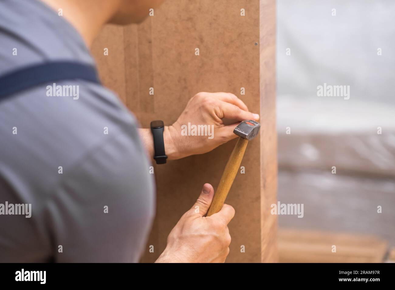 Managing carpentry business man installing shelf holders using hammer ...