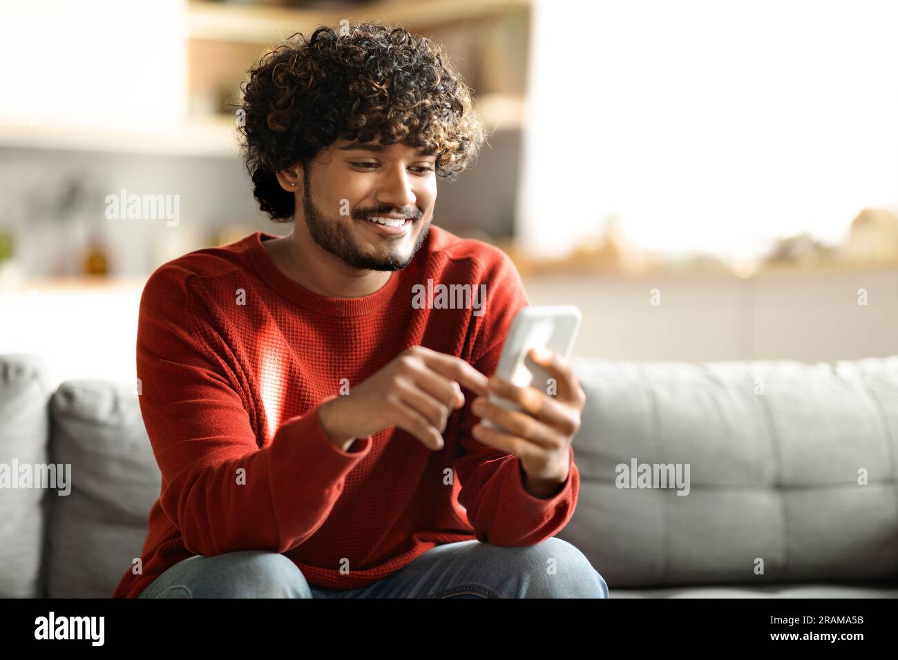 Great App. Smiling Indian Man Using Modern Smartphone At Home Stock ...