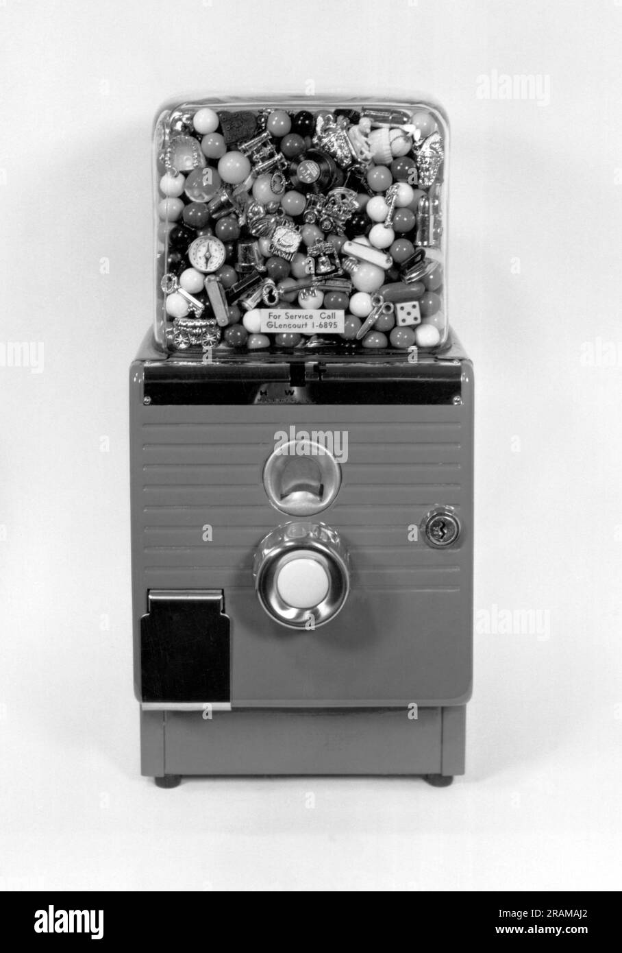United States: c. 1955 A gumball machine that dispenses gumballs and ...