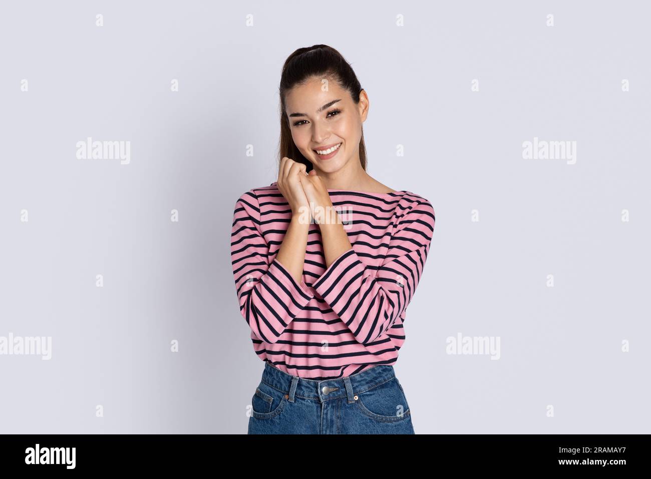 Cute pretty brunette woman holding hands next to face Stock Photo - Alamy