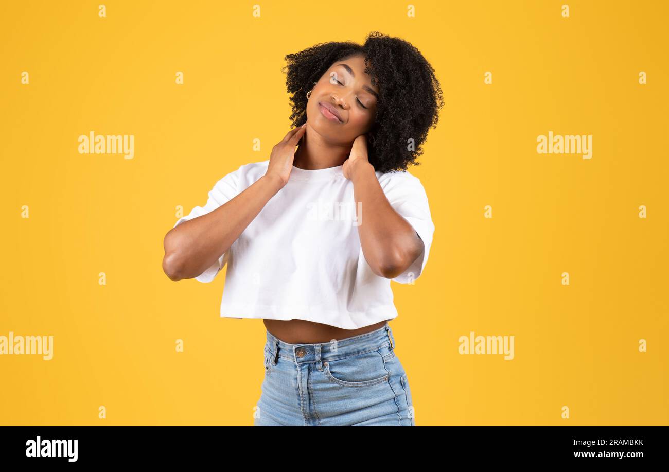 Sad millennial black woman in casual suffering from neck pain, isolated ...