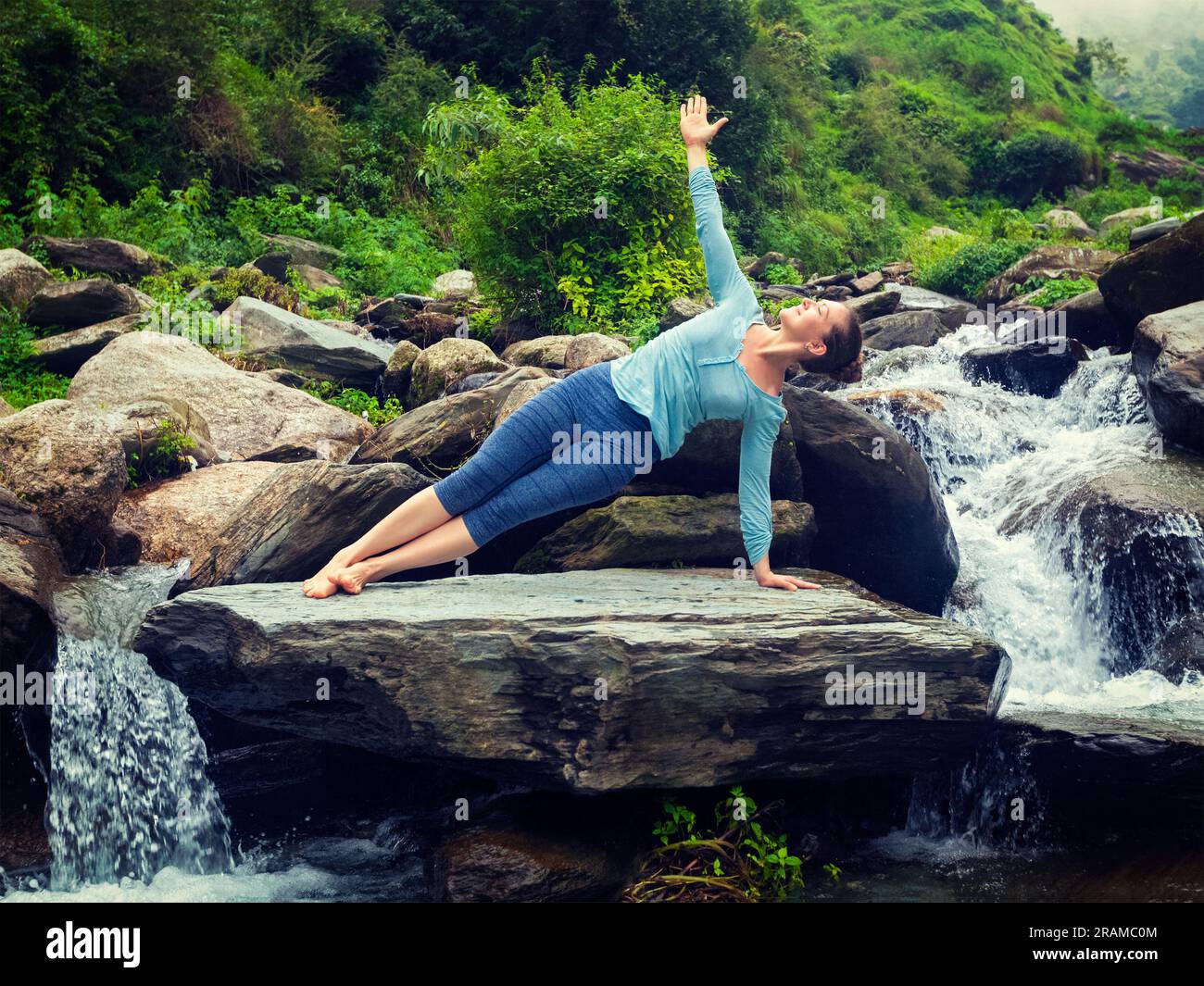 Woman doing yoga asana Vasisthasana - side plank pose outdoors Stock ...