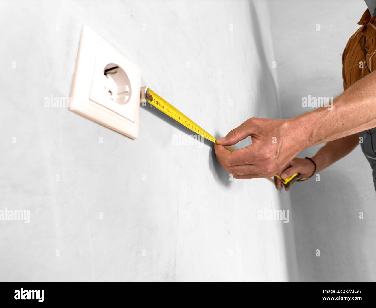 Hand holding measuring tool for wall measurement Stock Photo - Alamy