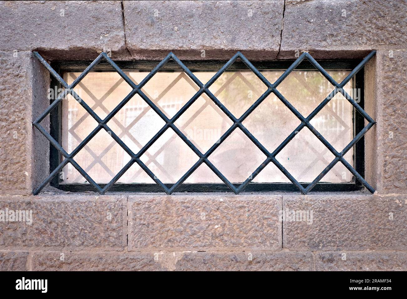 Window with iron cross bars, stone wall background Stock Photo - Alamy