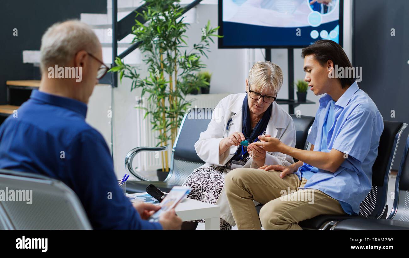 Specialist taking patient insulin level test using glucometer ...