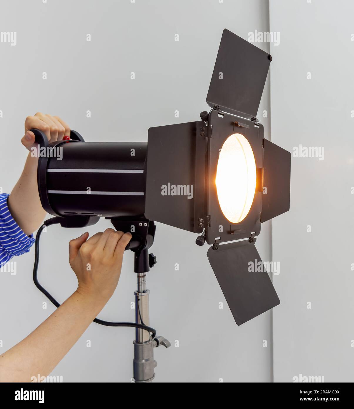 Hand of photographer adjusting, fixing reflector with doors attachment ...