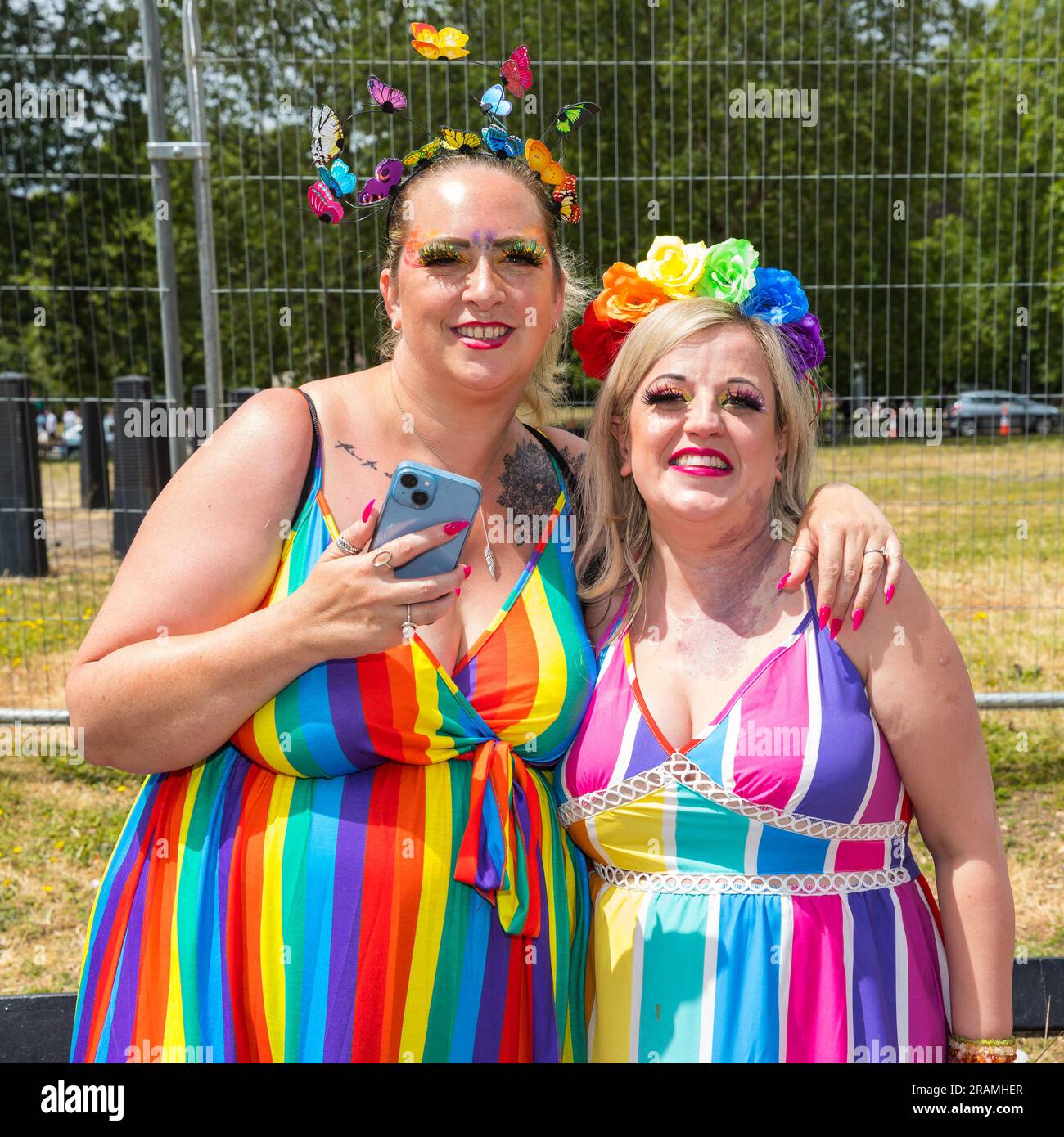 Two women in rainbow colours taking part in the Pride in London parade ...