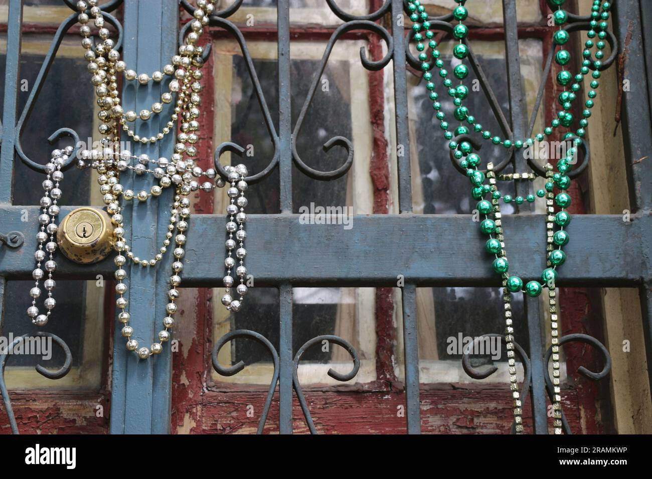 Colorful strands of green and silver Mardi Gras beads are draped on a ...