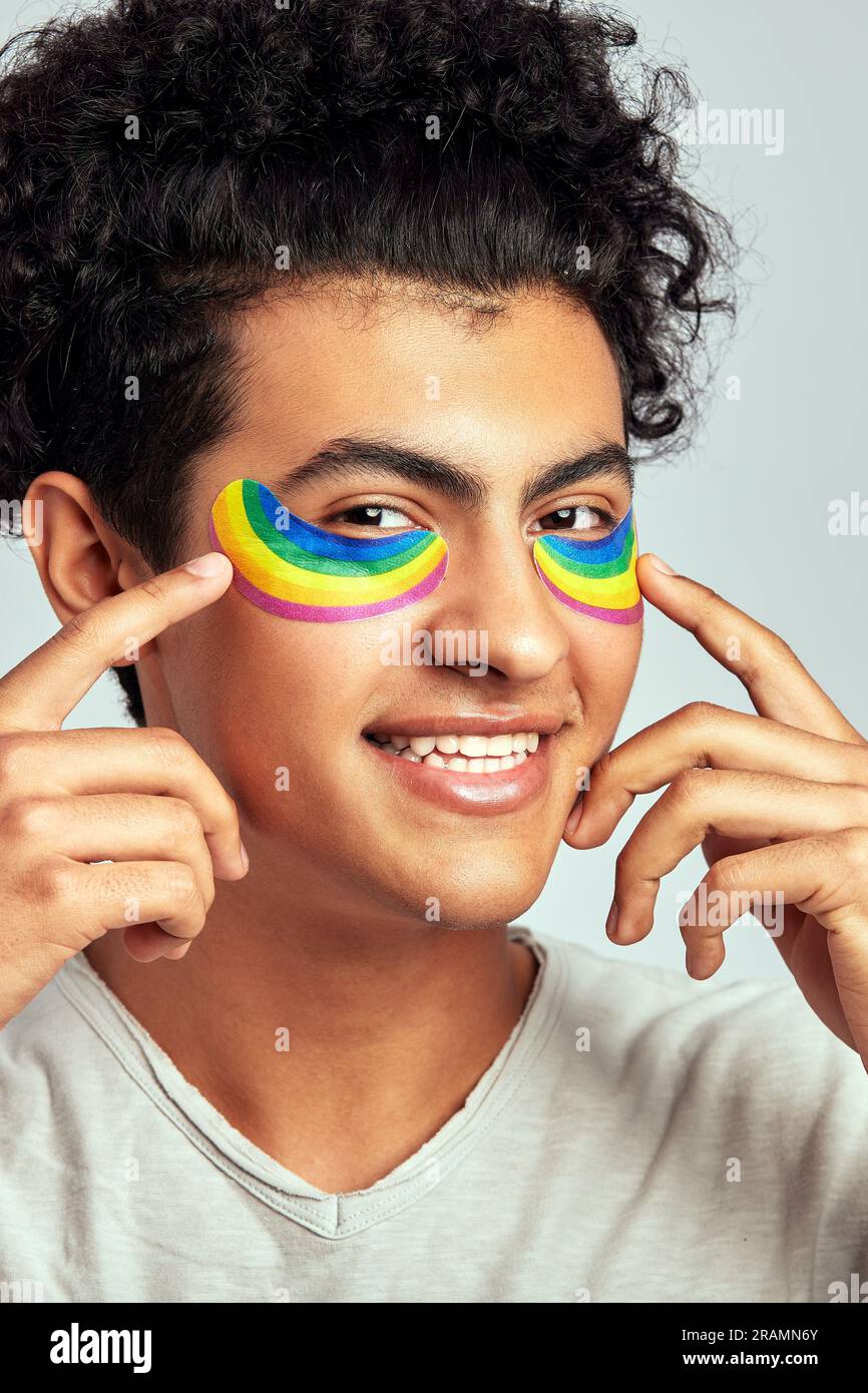 A young handsome guy with black curly hair applying cosmetic patches of ...