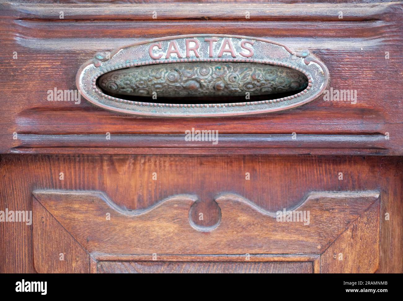 Ornamental metal oval letter box slot (mailbox) in elegant wooden door ...