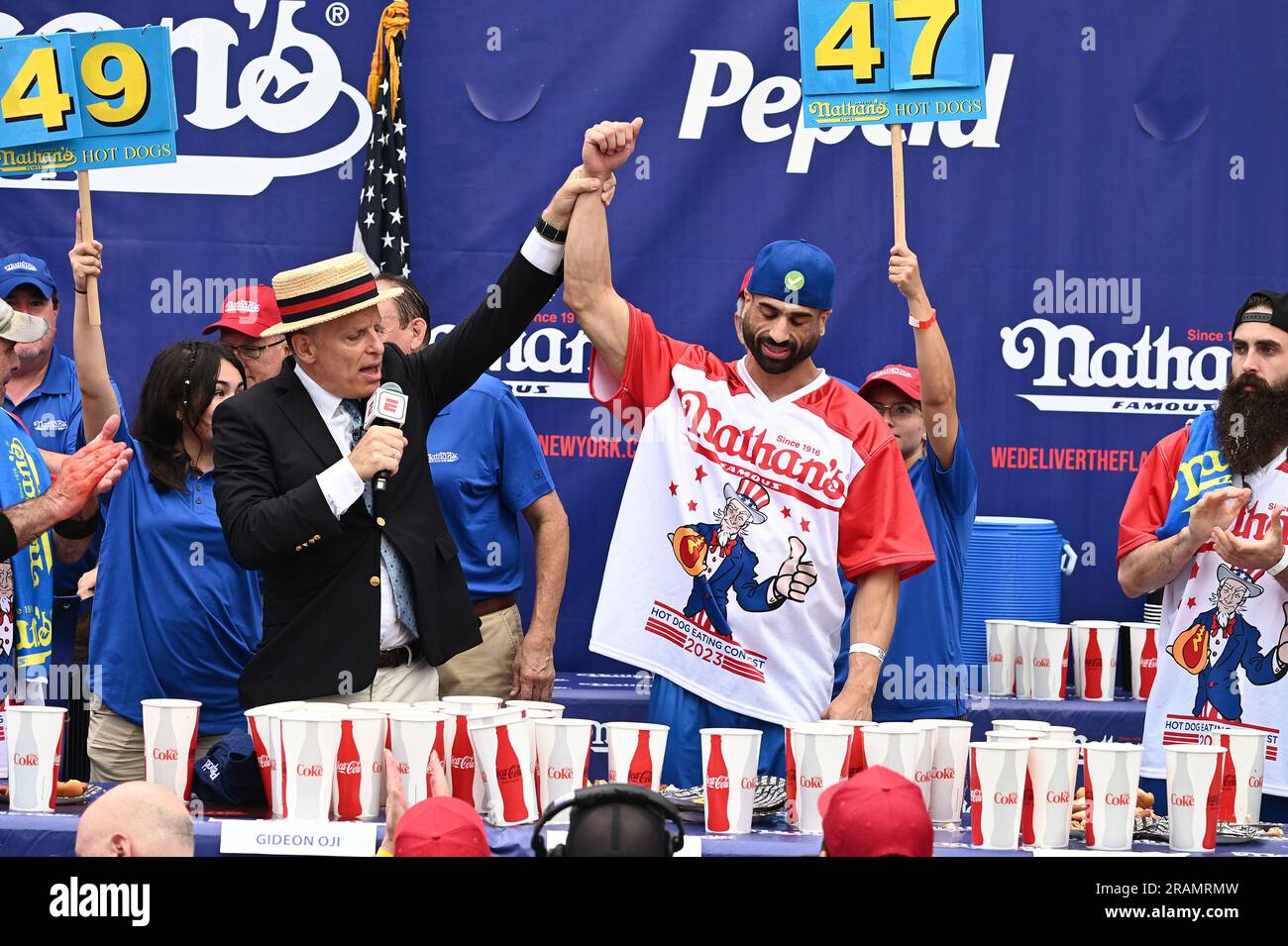 New York, USA. 04th July, 2023. Host George Shea (c) raises the hand of ...