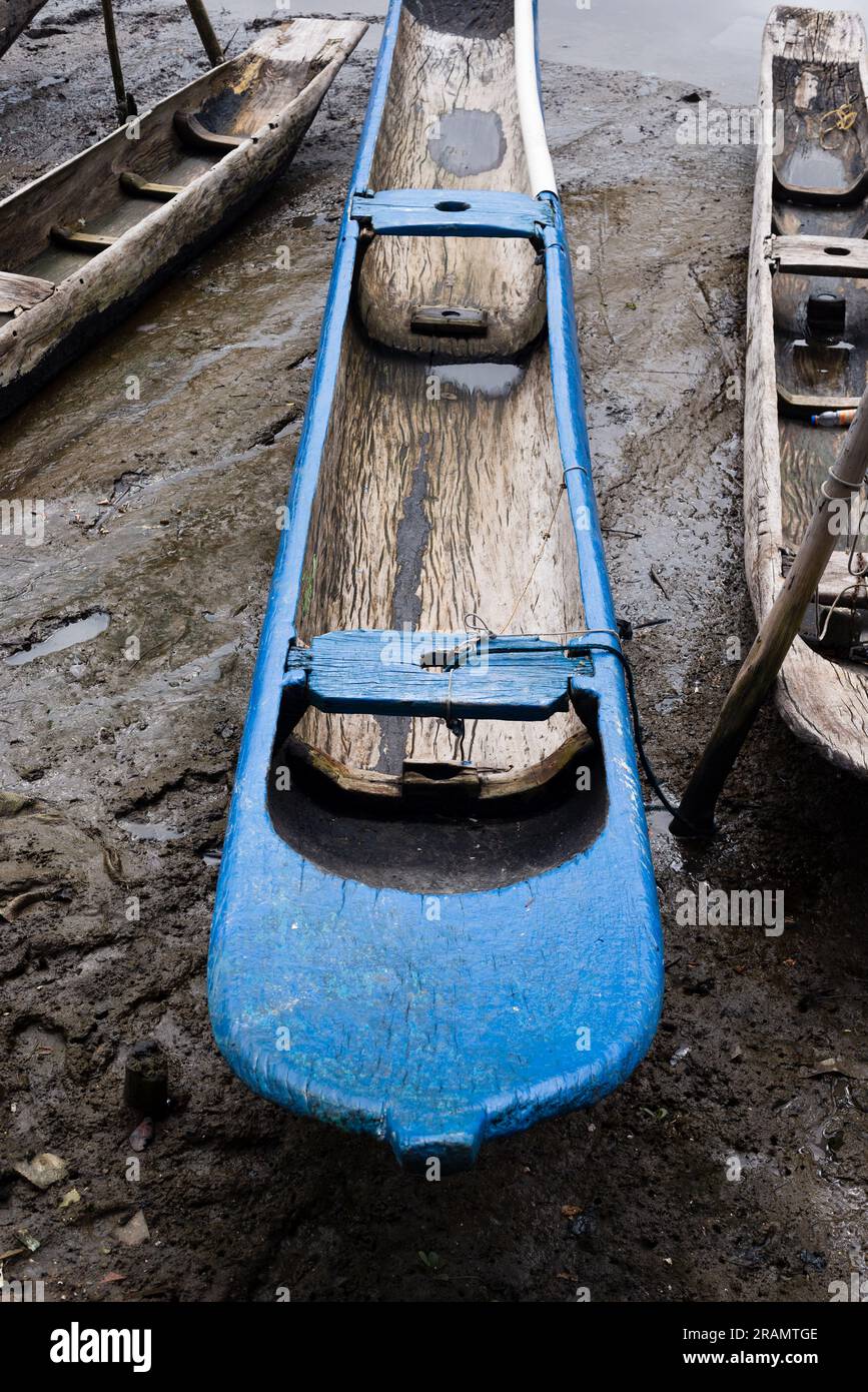 Blue and light colored fishing canoe resting on the sands of the river ...