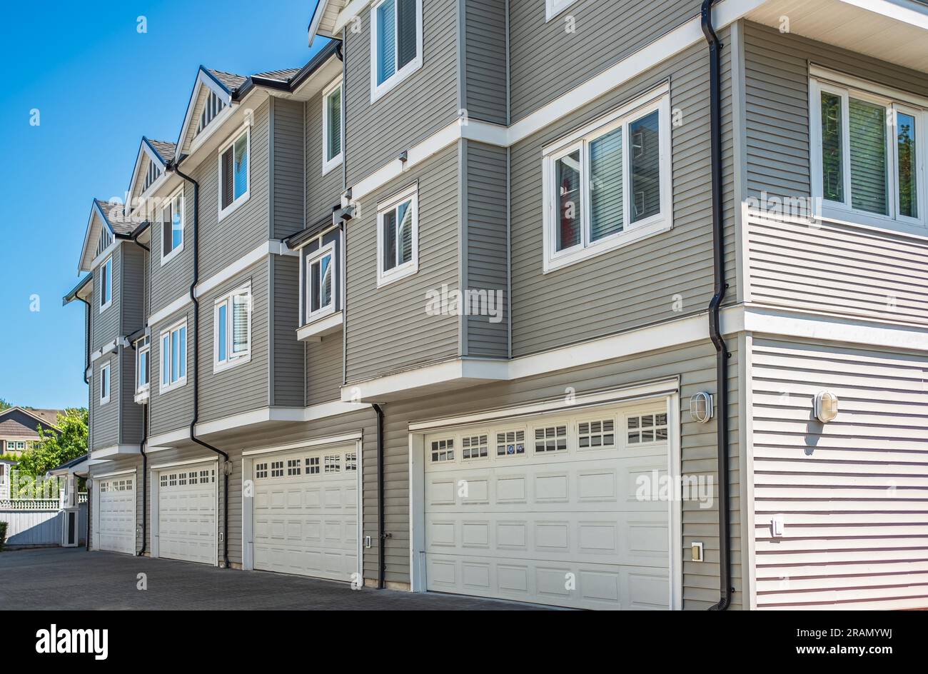Facade of new residential townhouses. Modern buildings with garages in ...