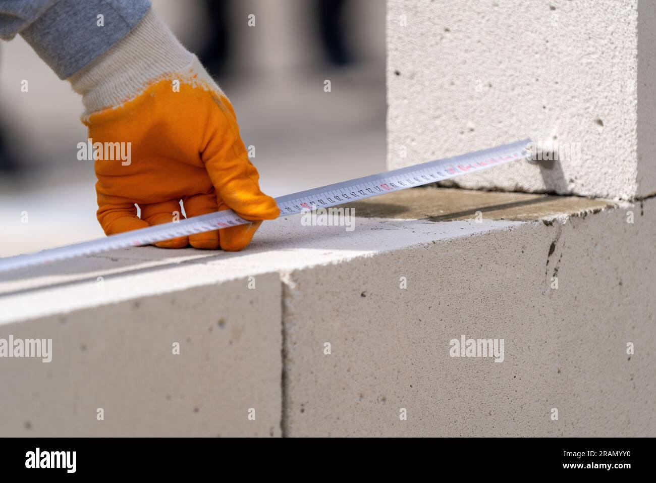 The bricklayer works to measure. Measuring with a meter Stock Photo - Alamy