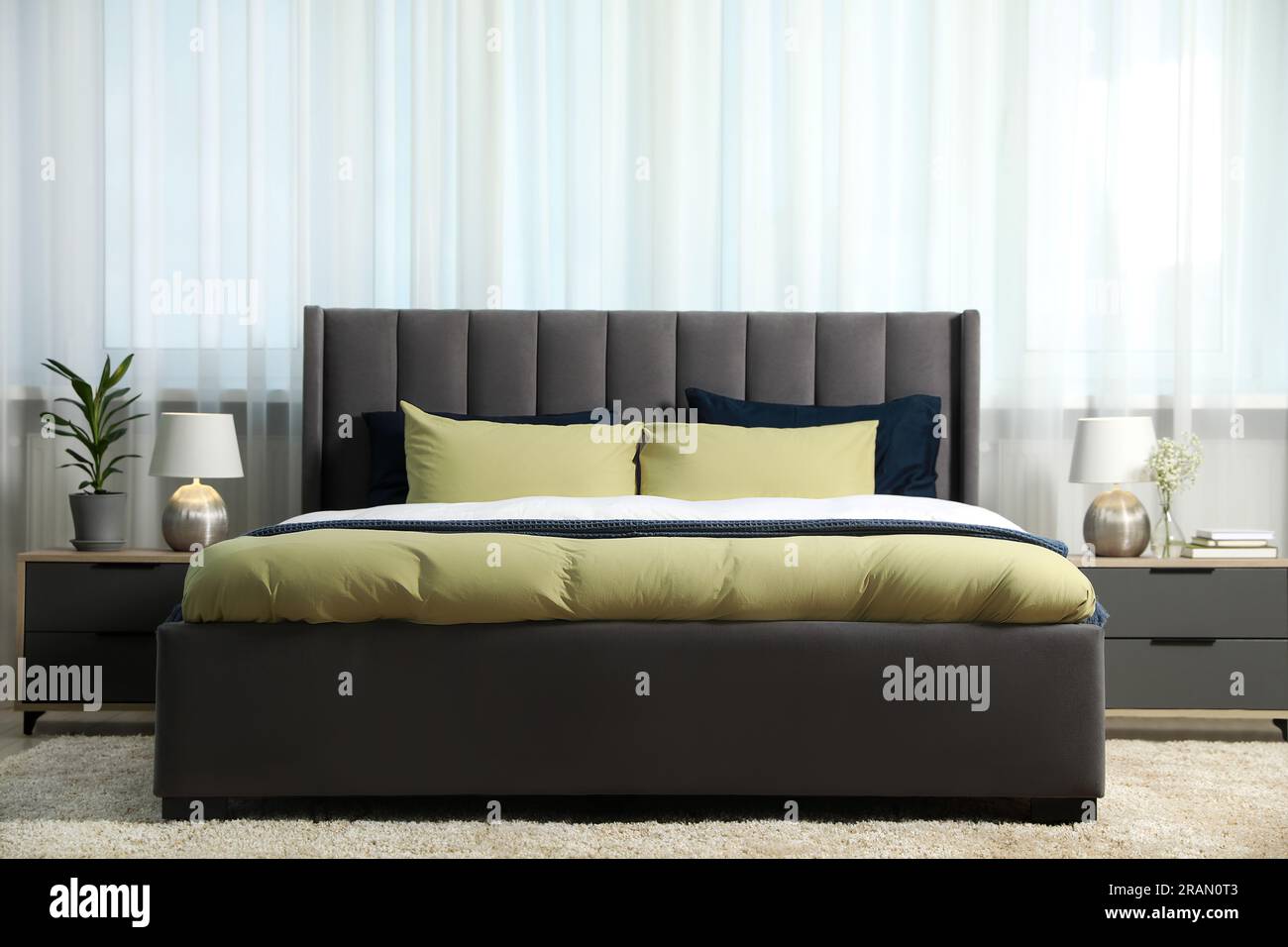Stylish bedroom interior with large comfortable bed Stock Photo - Alamy