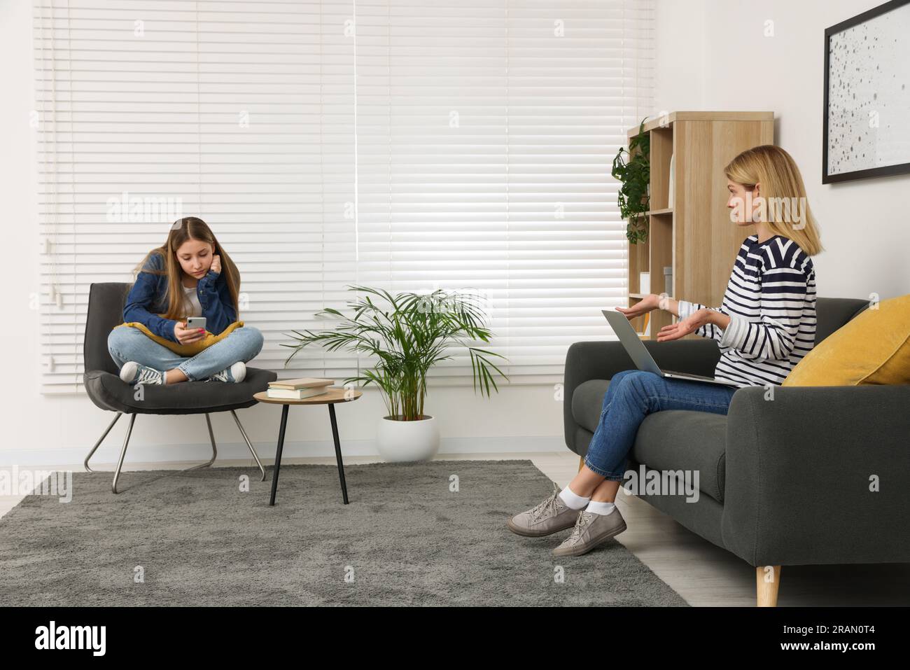Teenage daughter with smartphone ignoring her mother at home Stock Photo - Alamy