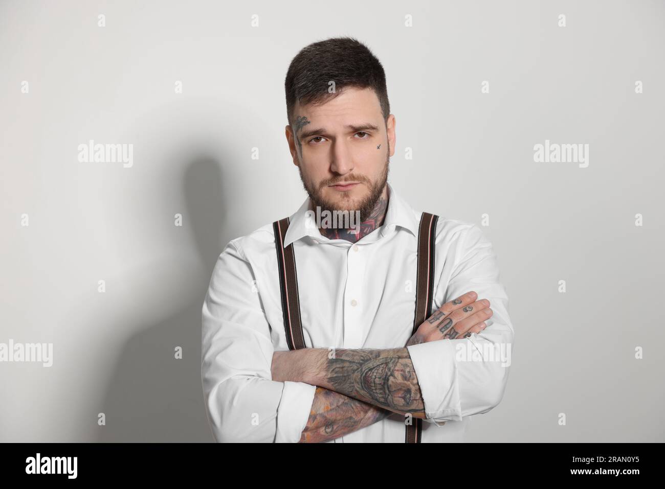 Portrait of handsome hipster man on light grey background Stock Photo ...