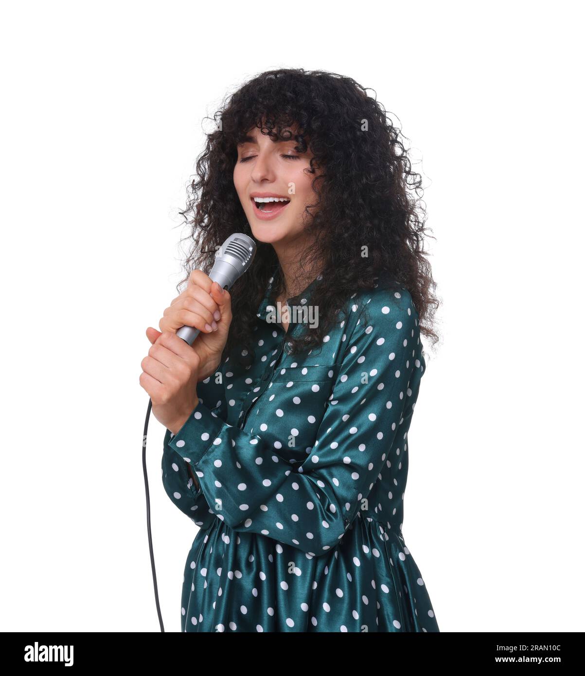 Beautiful young woman with microphone singing on white background Stock ...