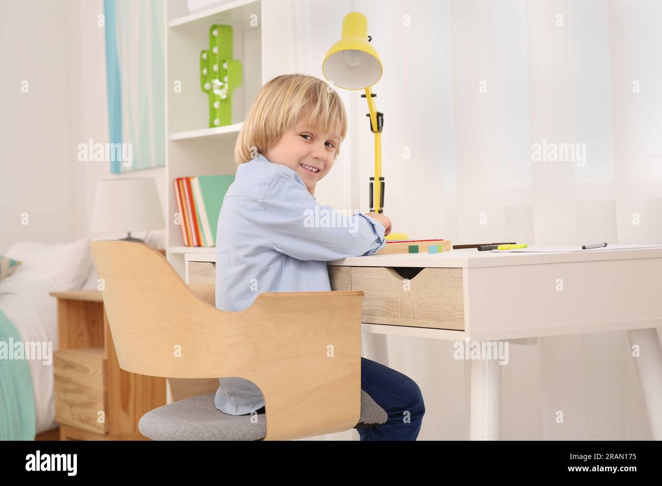 Boy sitting at desk hi-res stock photography and images - Alamy