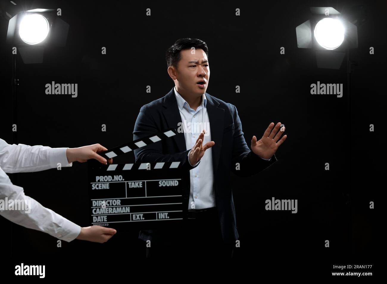 Emotional asian actor performing while second assistant camera holding ...