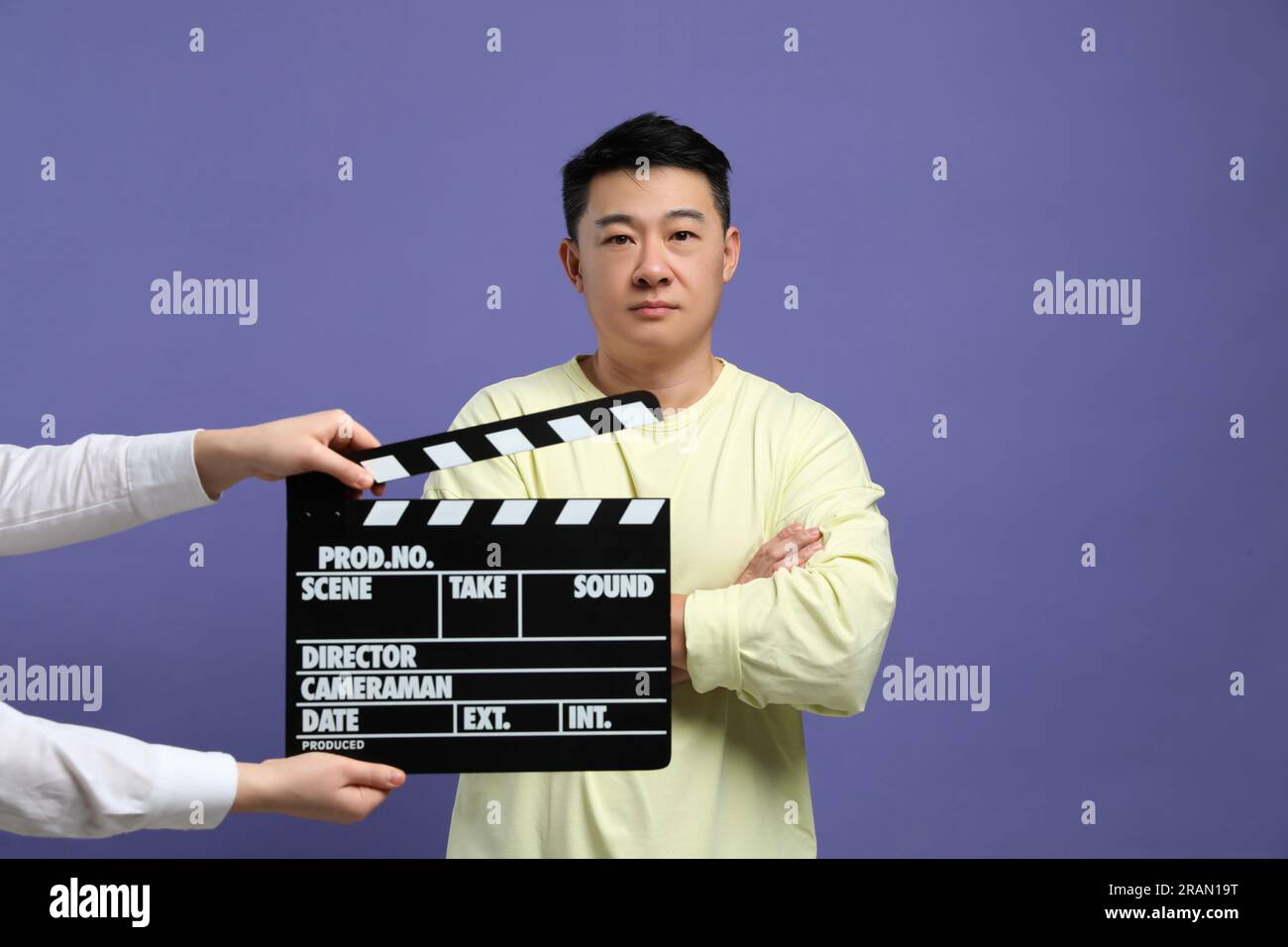 Asian actor performing while second assistant camera holding ...