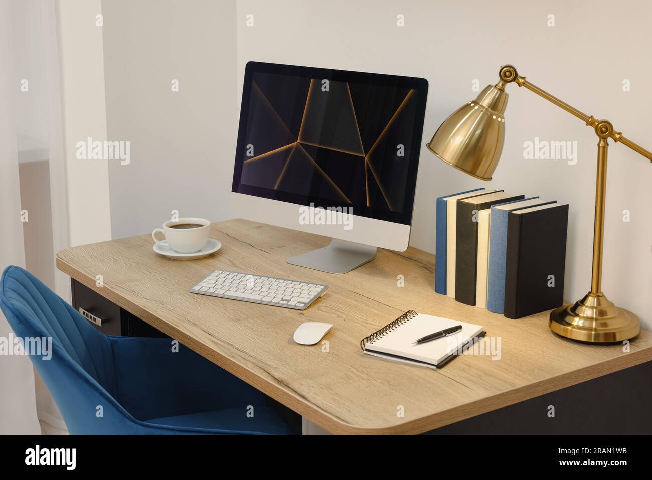 Cozy workspace with computer on wooden desk and comfortable chair at ...