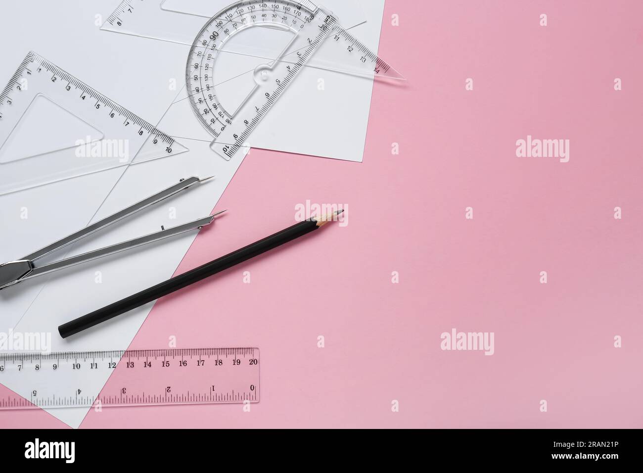 Different rulers, pencils and compass on pink background, flat lay ...