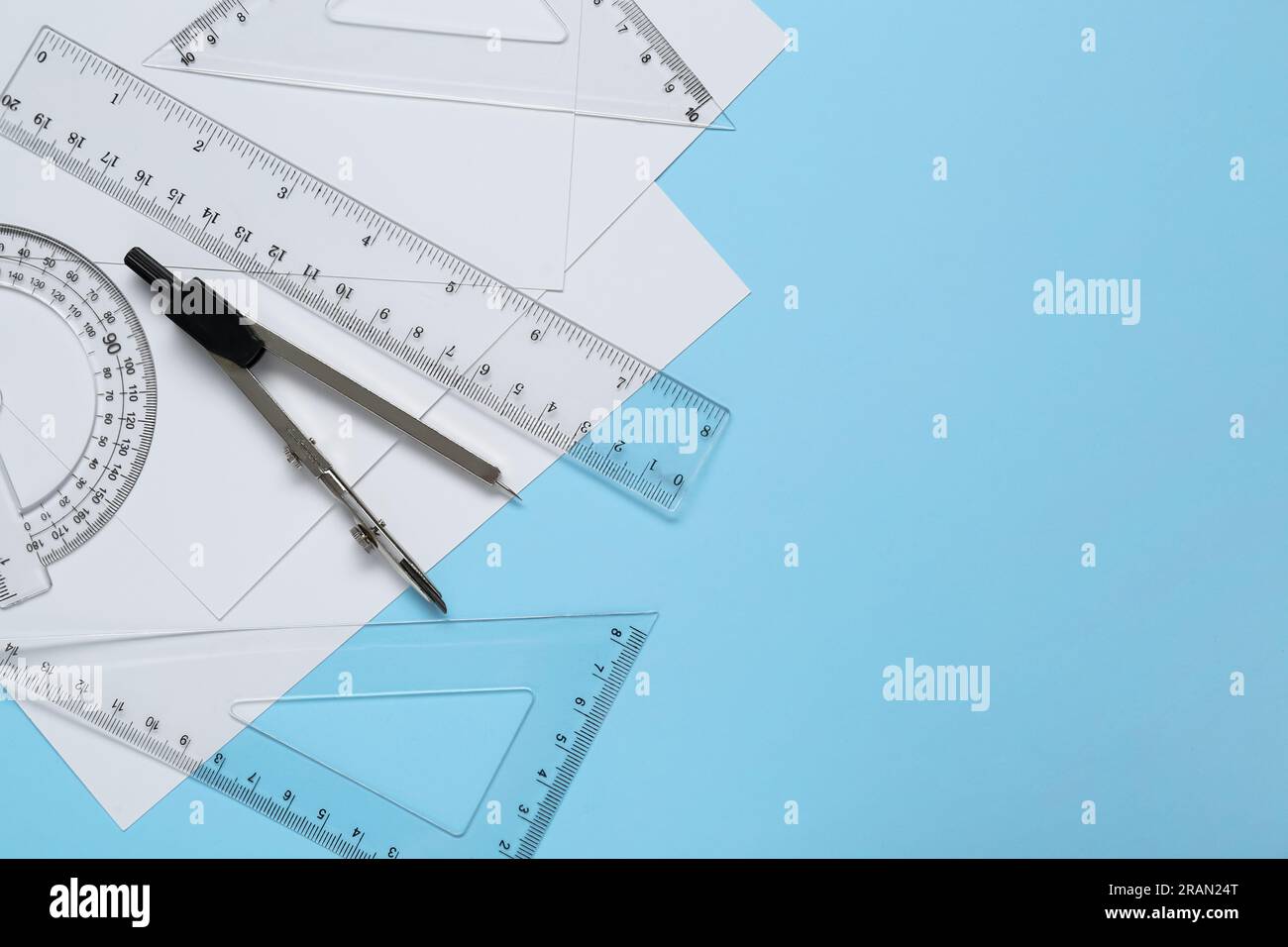 Flat lay composition with different rulers and compass on light blue ...