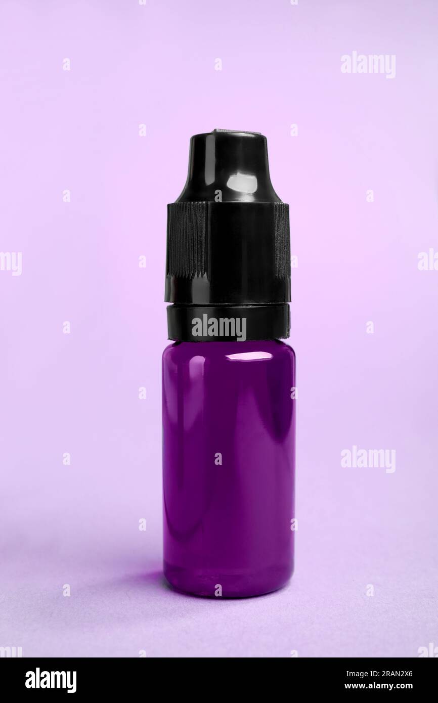 Bottle with purple food coloring on bright background Stock Photo - Alamy