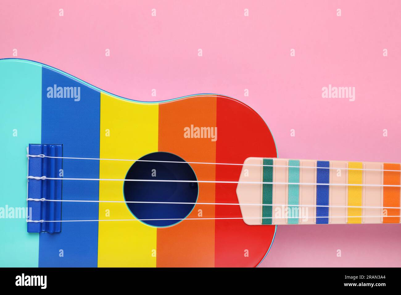 Colorful ukulele on pink background, top view. String musical ...