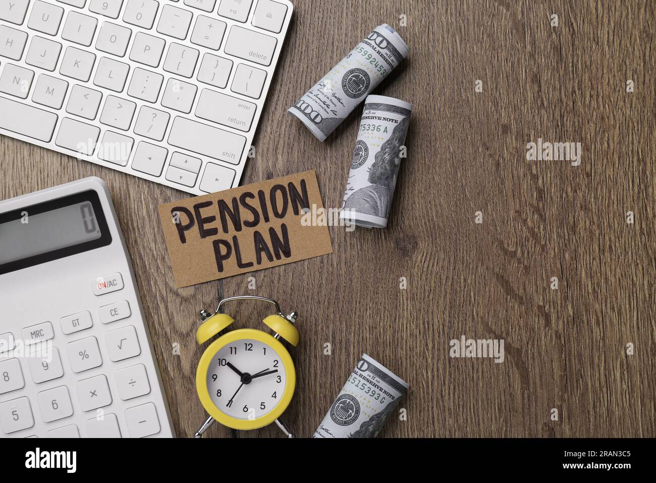 Card with words Pension Plan, banknotes, calculator and alarm clock on ...