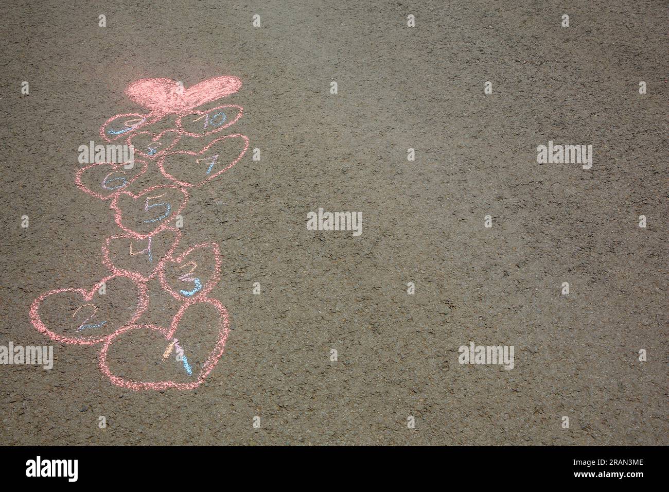 Hopscotch drawn with colorful chalk on asphalt outdoors. Space for text ...