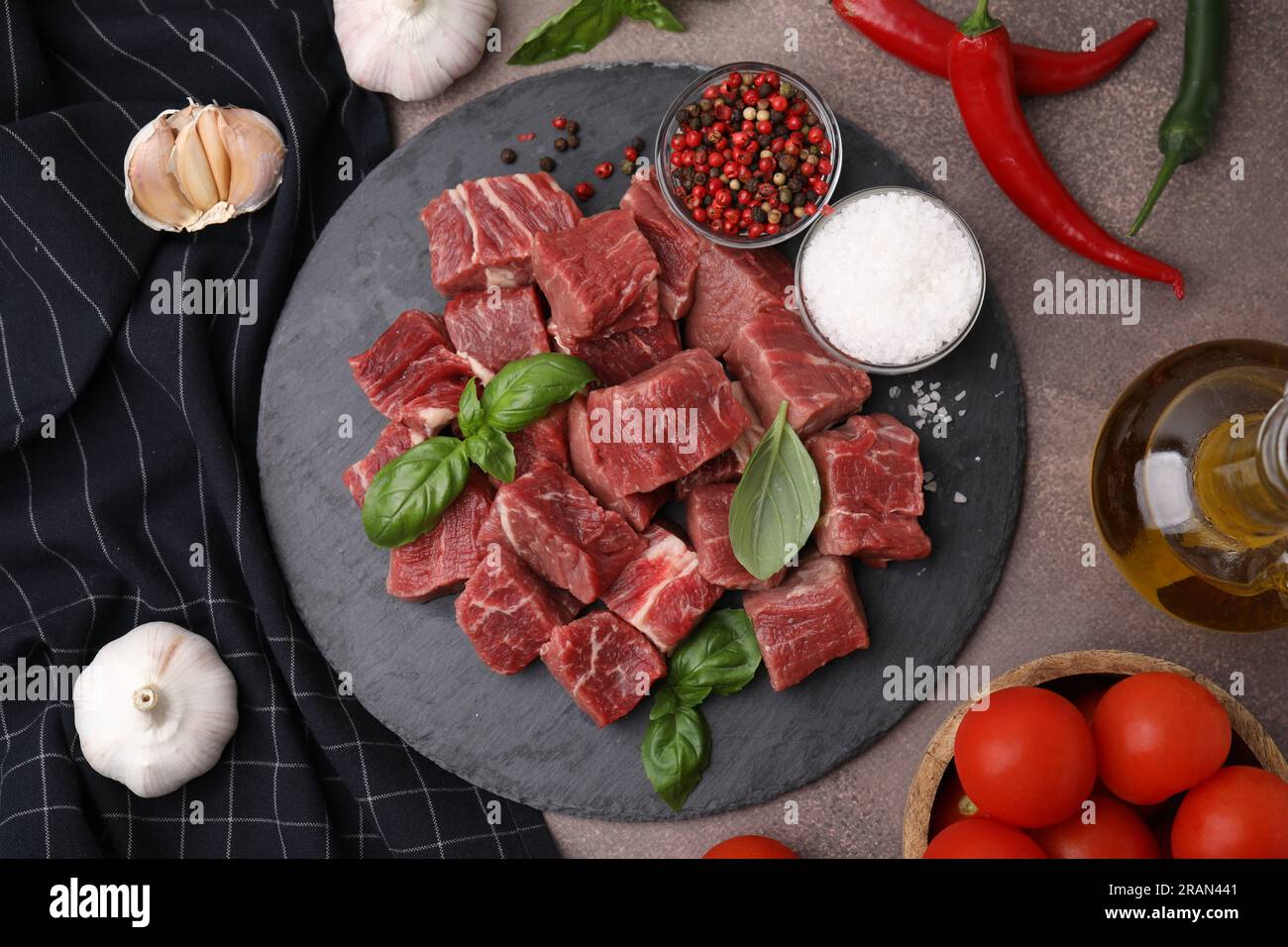 Flat lay composition with cut fresh beef meat on brown table Stock ...