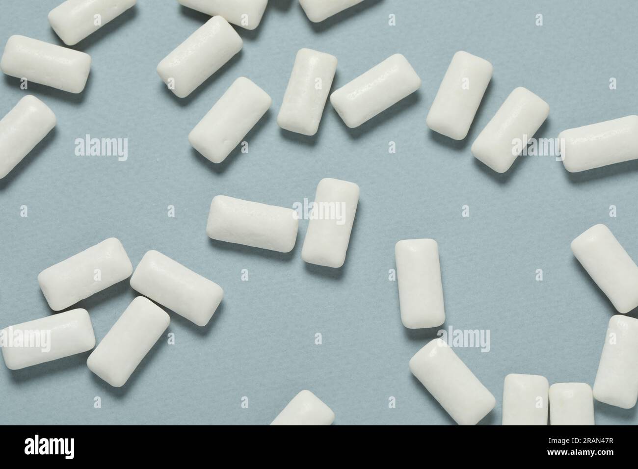 Tasty white chewing gums on light blue background, flat lay Stock Photo ...