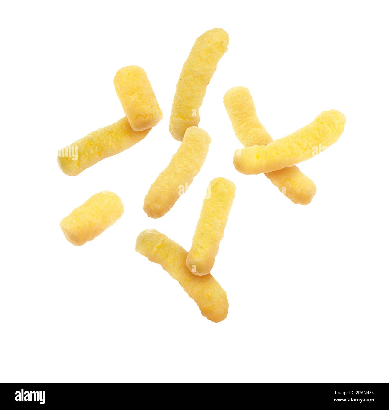 Many tasty corn sticks falling on white background Stock Photo - Alamy