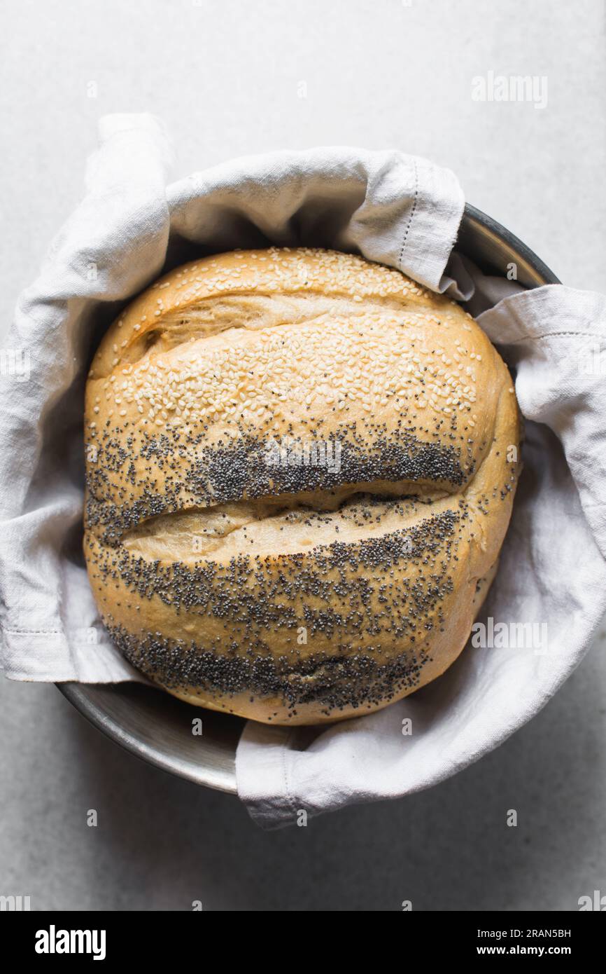 Top view of round homemade bread on a marble tray, Potbrood coated with ...