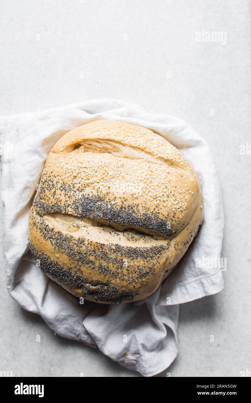 Top view of round homemade bread on a marble tray, Potbrood coated with ...