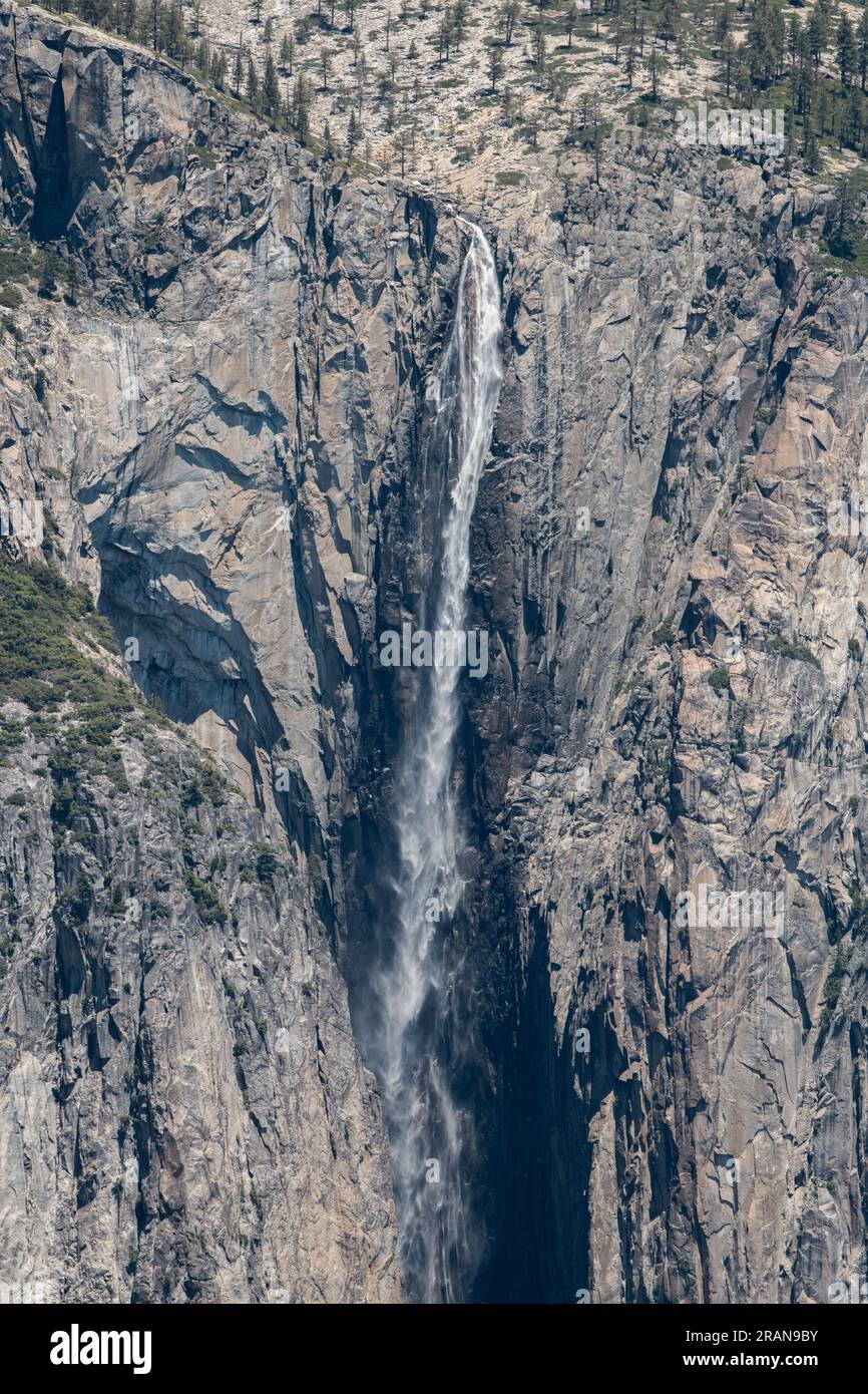A river flowing off a cliff and the resulting waterfall in Yosemite ...