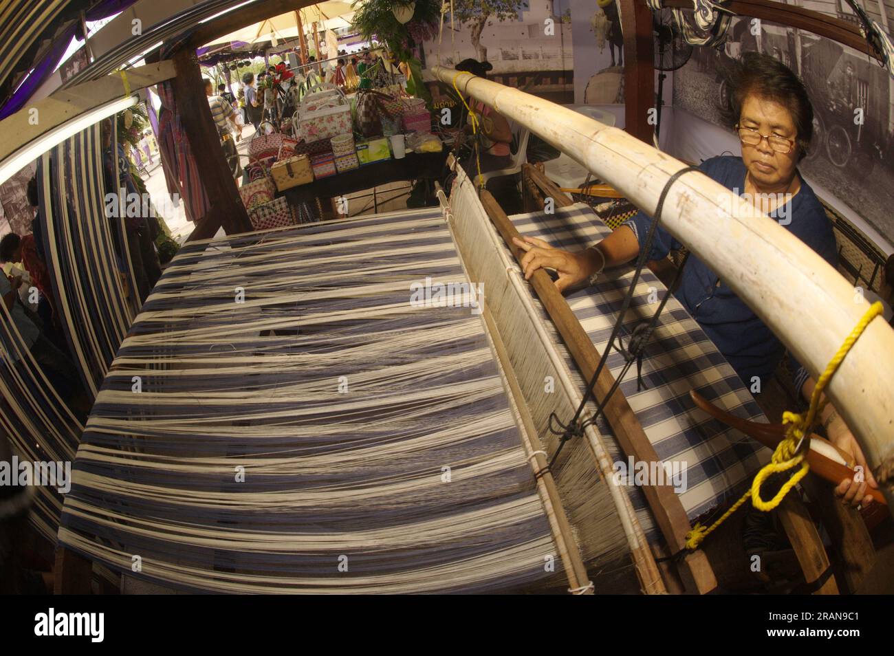 An unidentified elderly woman weaving large fabrics on an old loom for ...