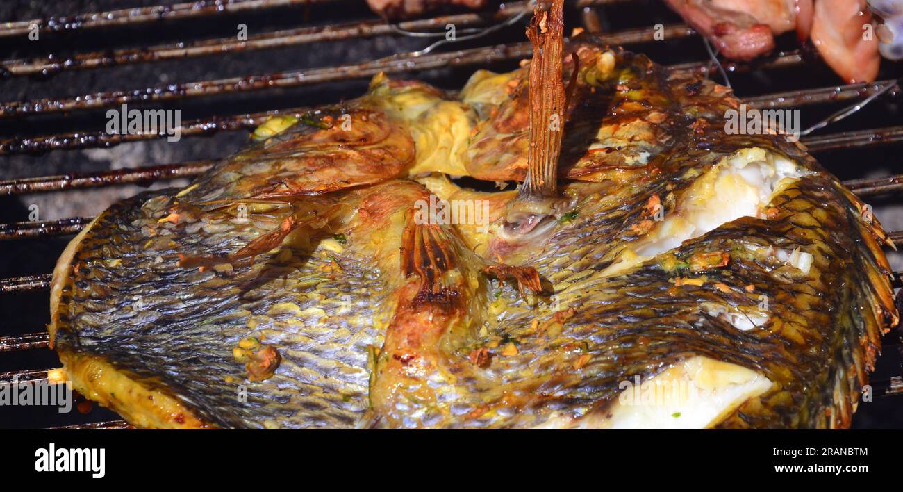 Cooked fish on a hot griddle at a street food stall in Jomtien, Pattaya ...