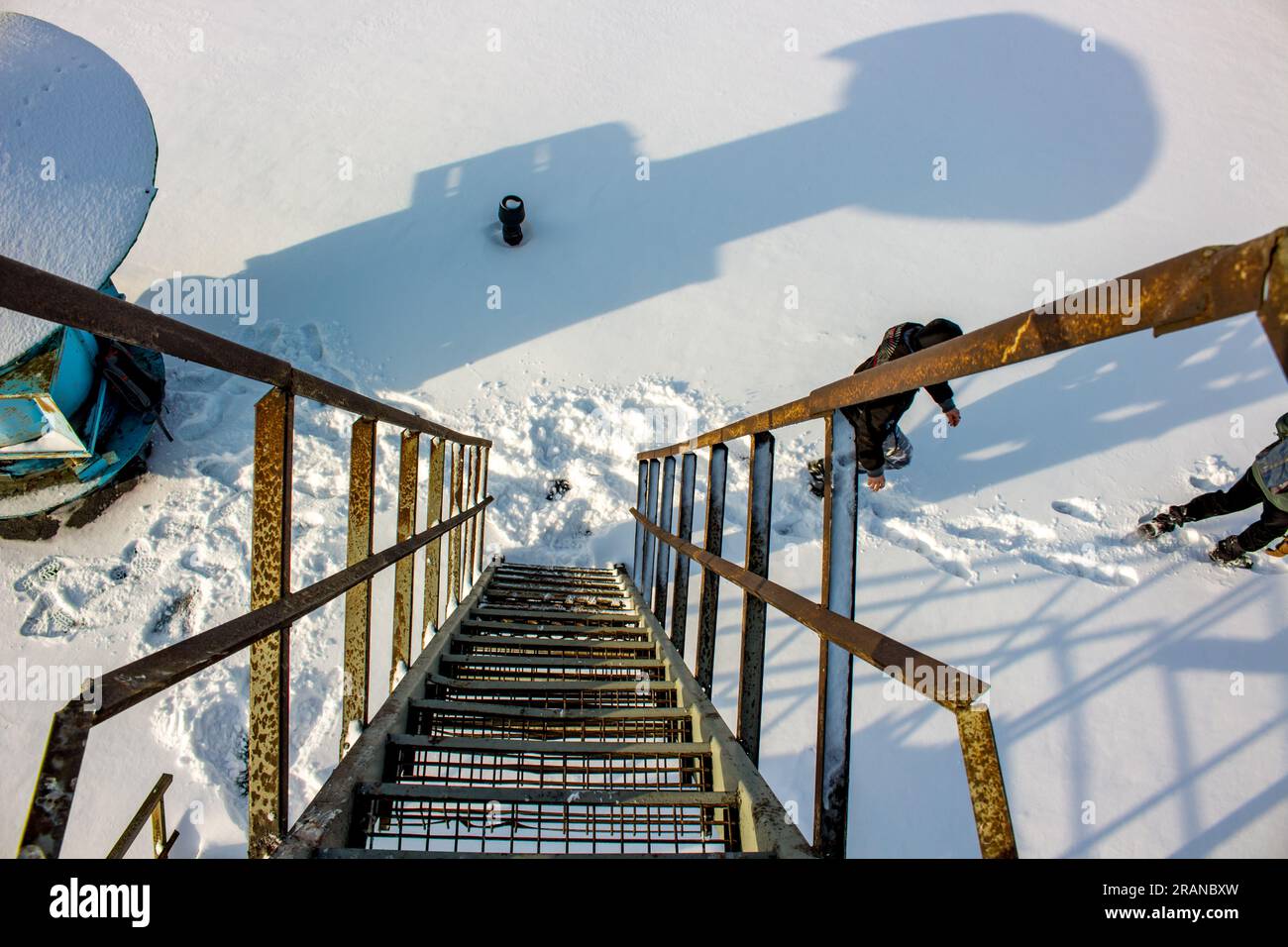 Fire escape metal ladder on a high-rise building, downhill, winter day ...