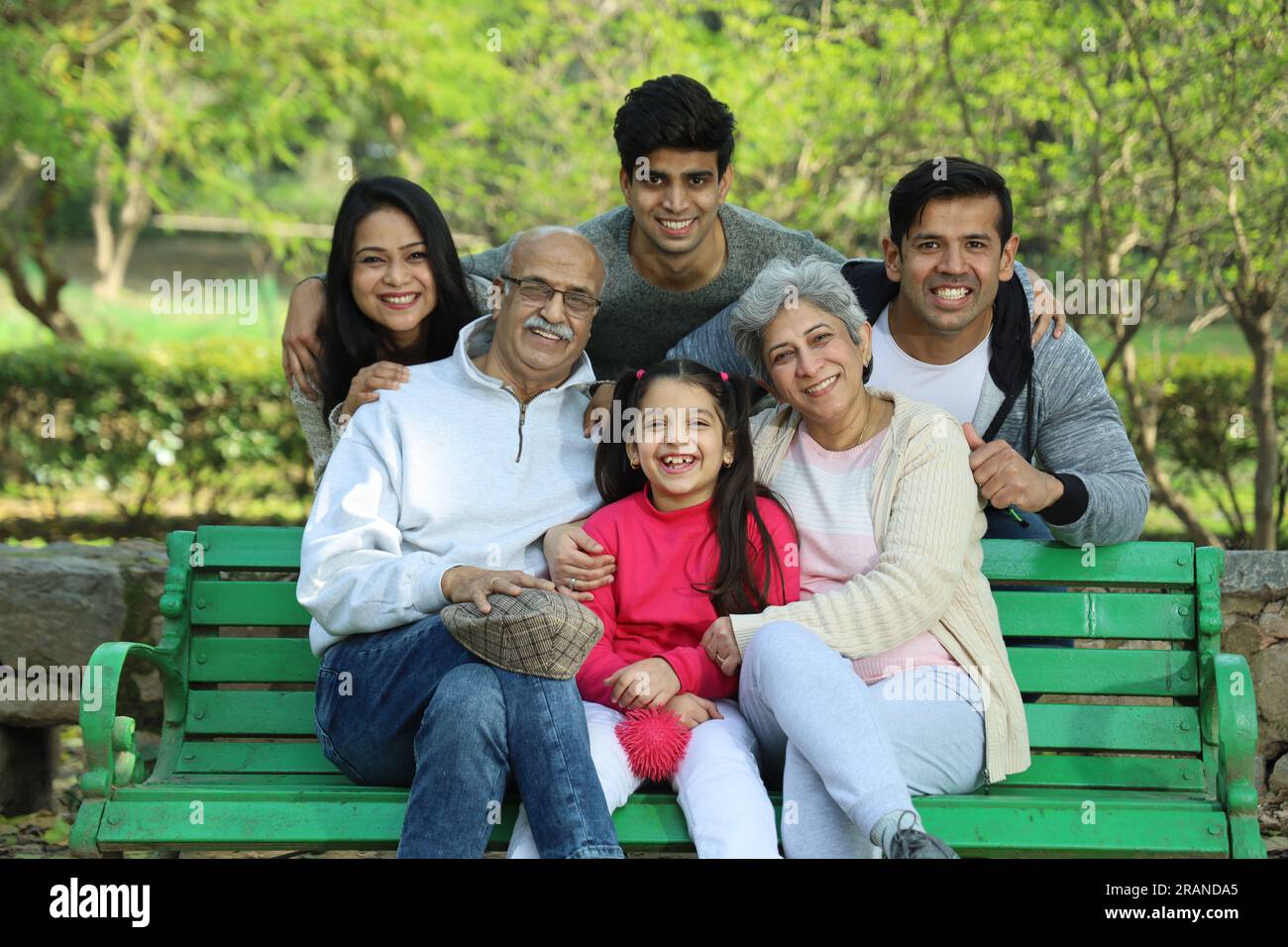 Family sitting on bench hi-res stock photography and images - Alamy