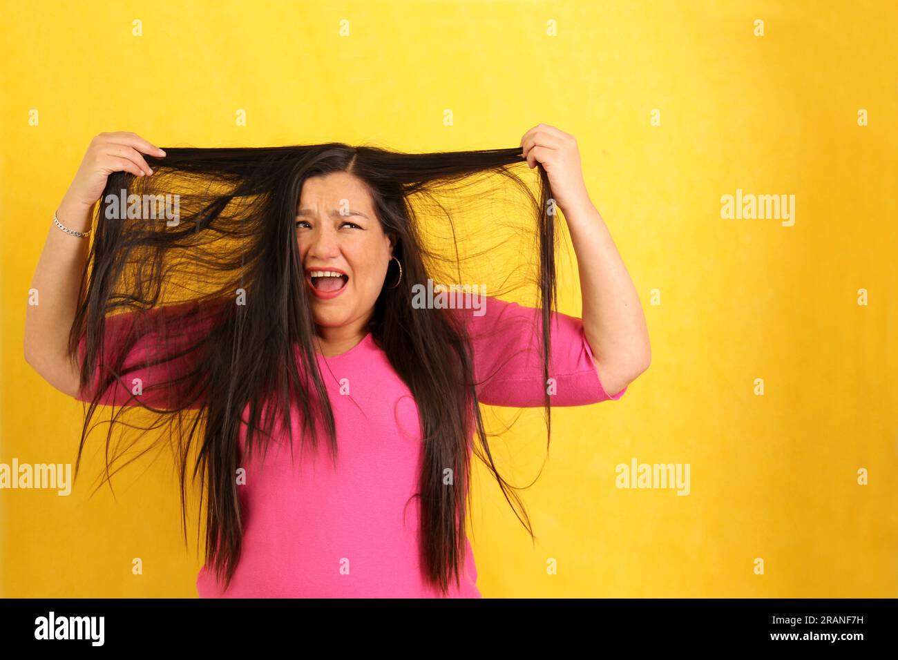 Adult 40-year-old Latina woman ruffles her hair desperate with anxiety ...
