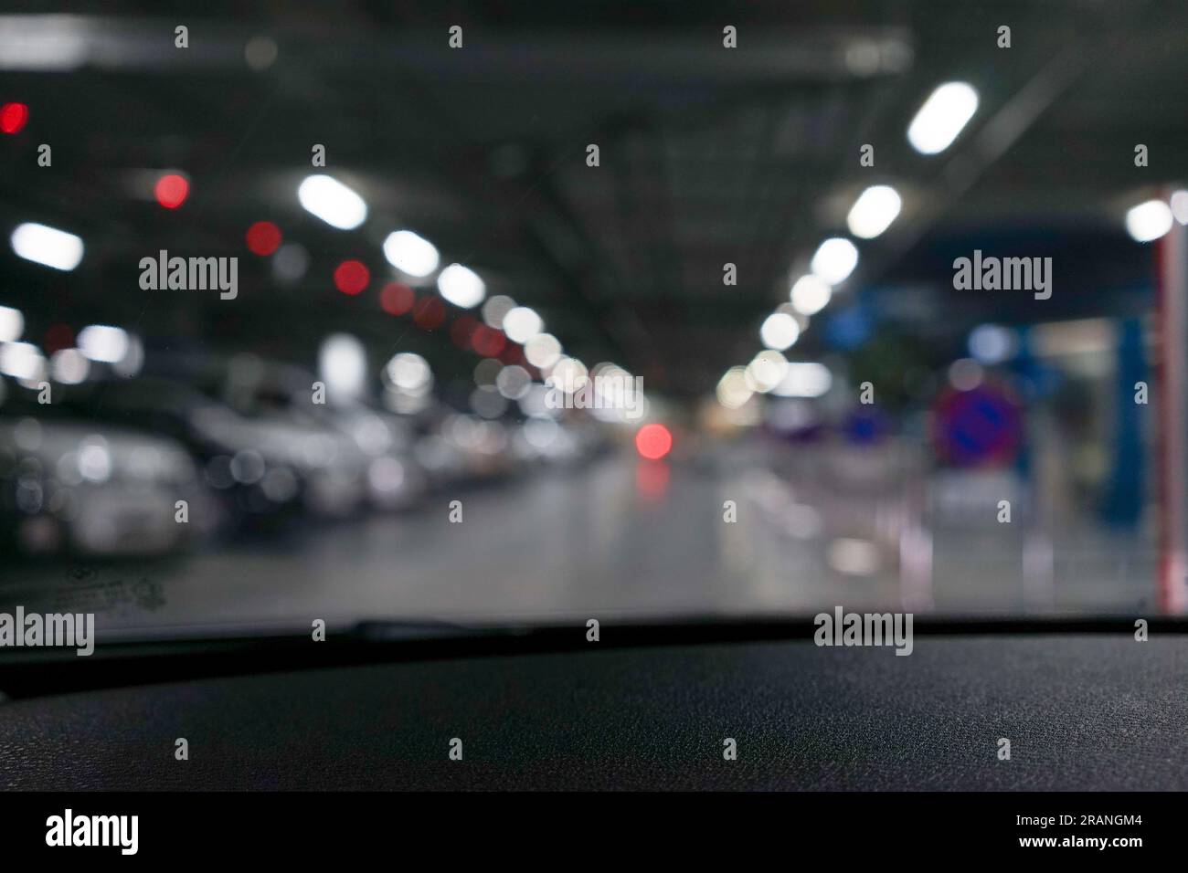 Blured image of Many cars in parking lot at mall from inside the car ...