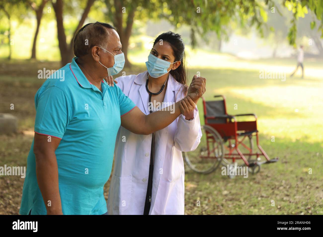 Female Doctor taking care of senior patient in hospital garden. The ...