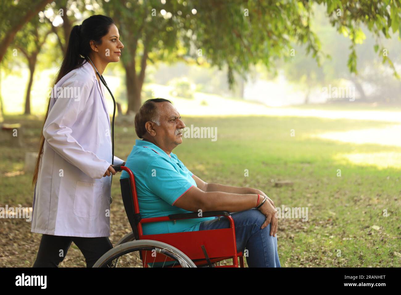 Female Doctor taking care of senior patient in hospital garden. The ...