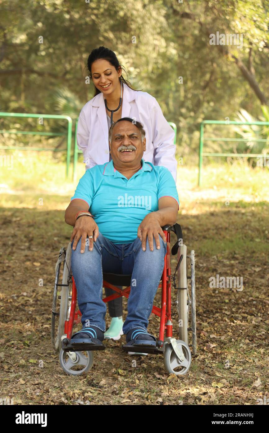 Female Doctor taking care of senior patient in hospital garden. The ...