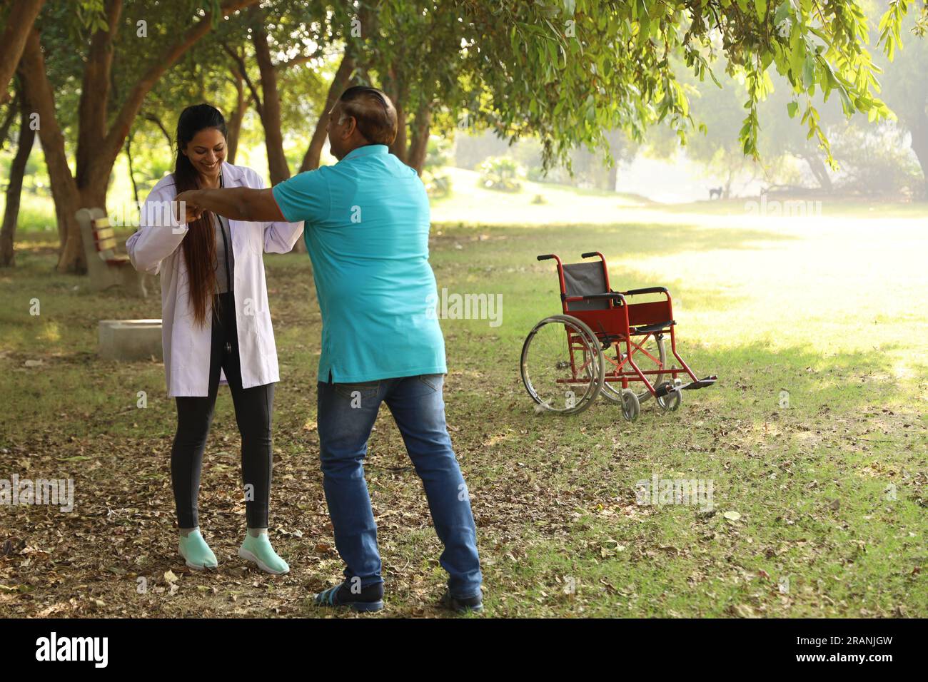Female Indian Doctor taking care of senior patient in hospital garden ...