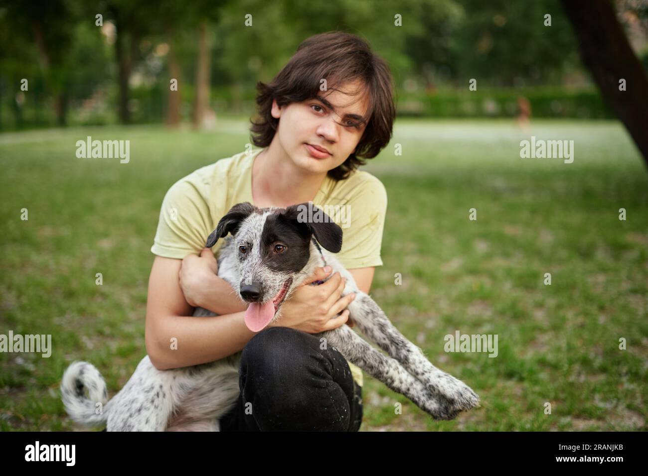 Outdoor portrait of boy with his adopted dog. Friendship of teenager ...