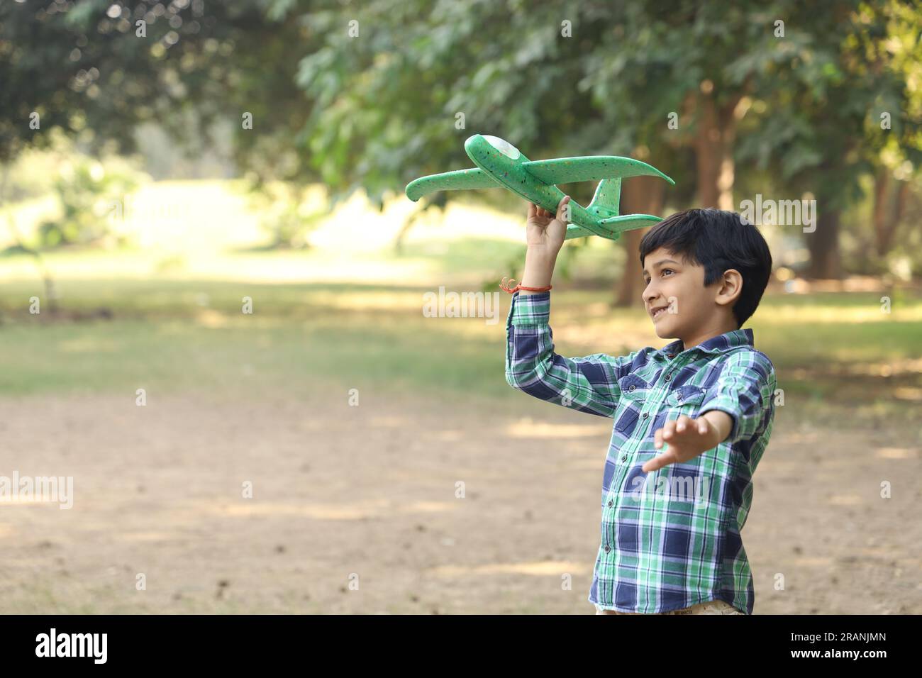 family having a good time in a park. they are grooming their son and ...